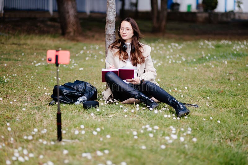 Female Student Virtual Learning on Mobile Outdoors Sitting in Park ...