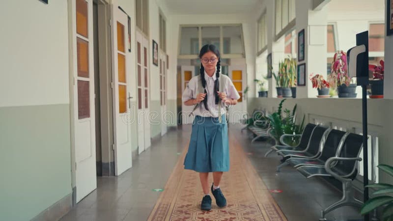 A Female Student Walking Alone in the School Hallway with a Sad ...