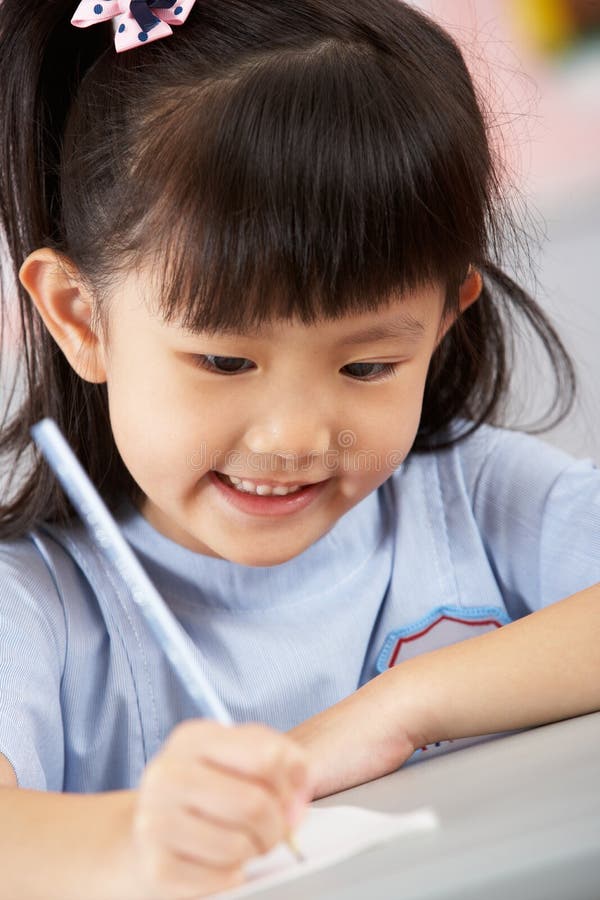 Female Student Working at Desk in School Stock Photo - Image of ...