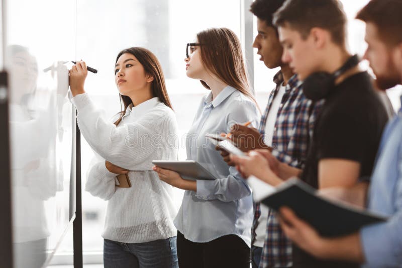 Female Student Writing on Board in Classroom Stock Photo - Image of ...
