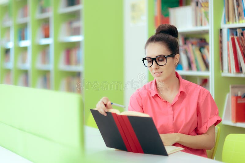 Female Student Writing an Essay Assignment in School Library Stock ...