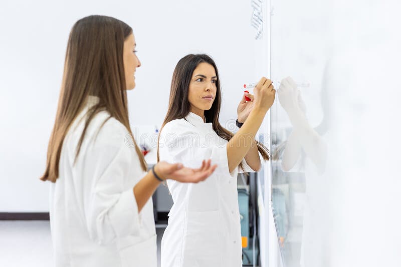 Female Student Writing on Glass Board in Classroom. Stock Image - Image ...