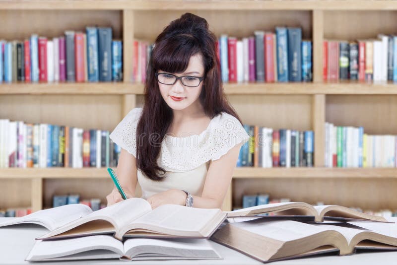 Female Student Writing in the Library Stock Photo - Image of exam ...