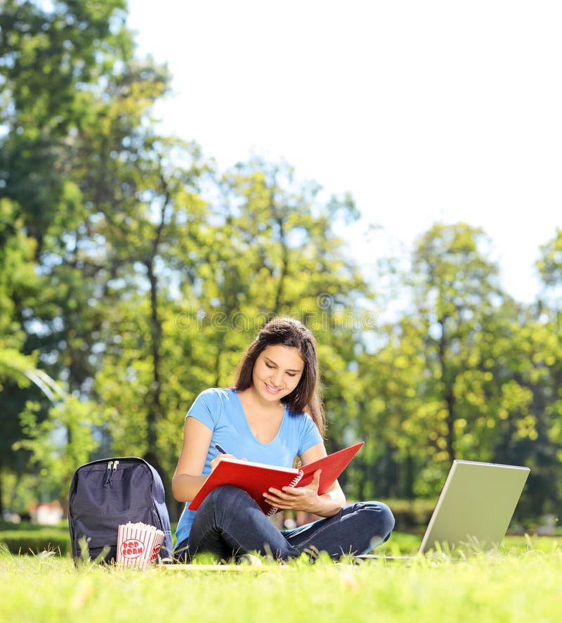 Female Student Writing in a Notebook Outdoors Stock Image - Image of ...