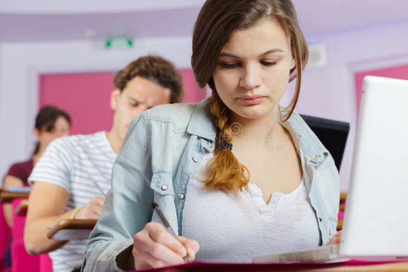Female Student Writing Notes in Class Stock Image - Image of indoors ...