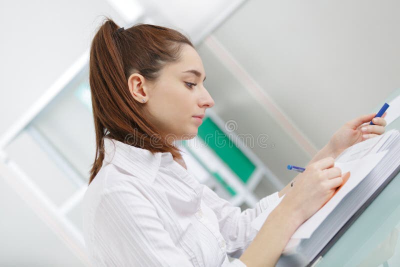 Female Student Writing Notes at Desk in Library Stock Image - Image of ...