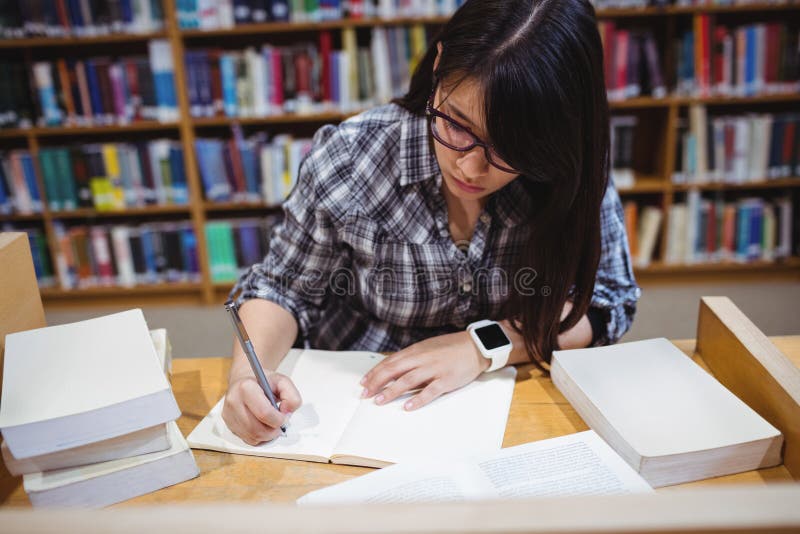 Female Student Writing Notes in Library Stock Photo - Image of sitting ...