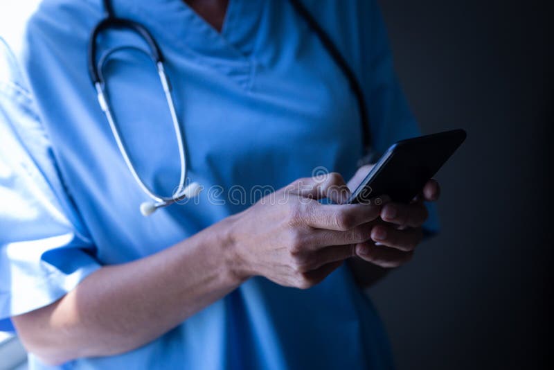 Female Surgeon Using Mobile Phone in Hospital Corridor Stock Photo ...