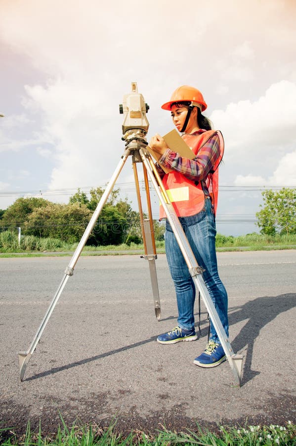 Female Surveyor or Engineer Making Measure on the Field. Stock Photo ...