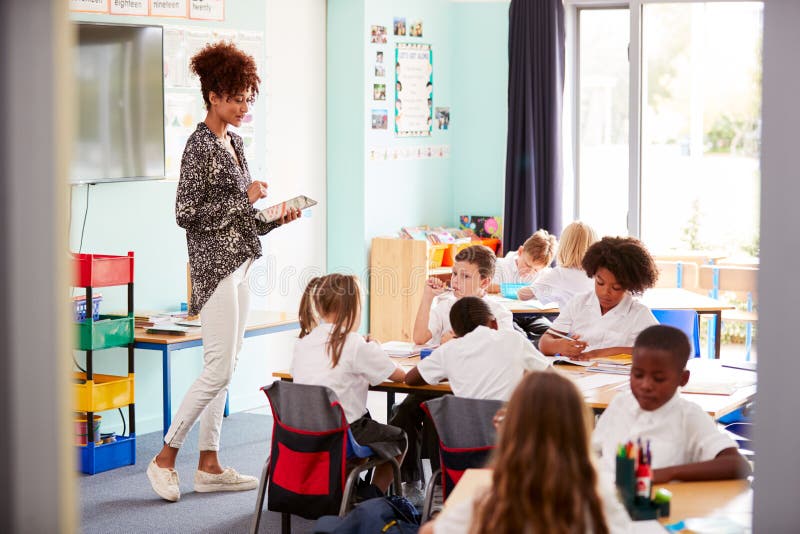 Female Teacher with Digital Tablet Teaches Group of Uniformed ...