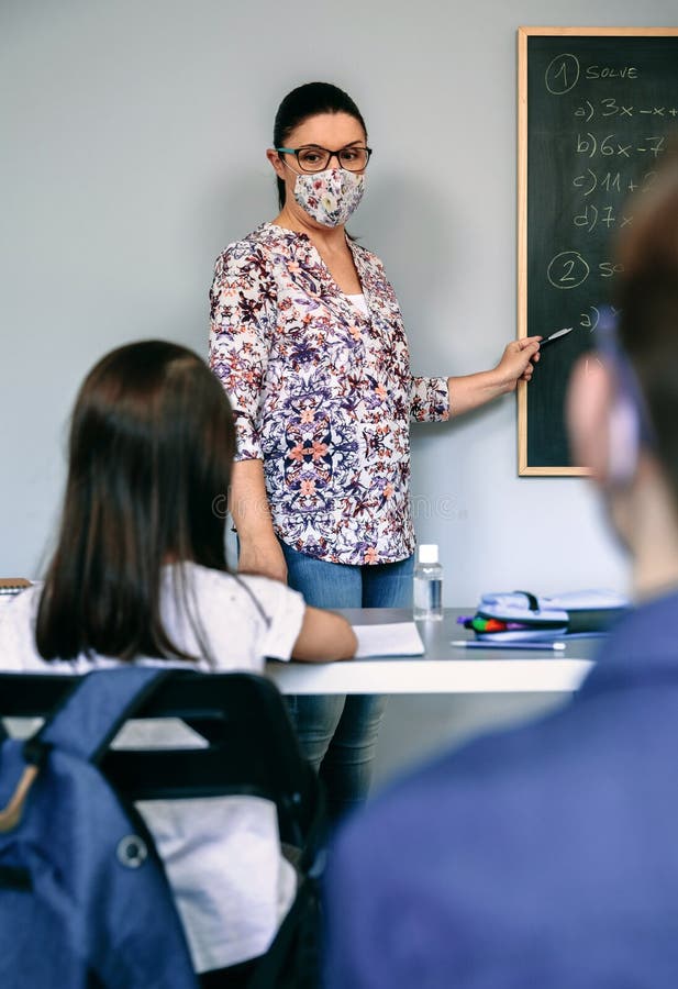 Teacher with Mask Explaining Exercises in Math Class Stock Photo ...