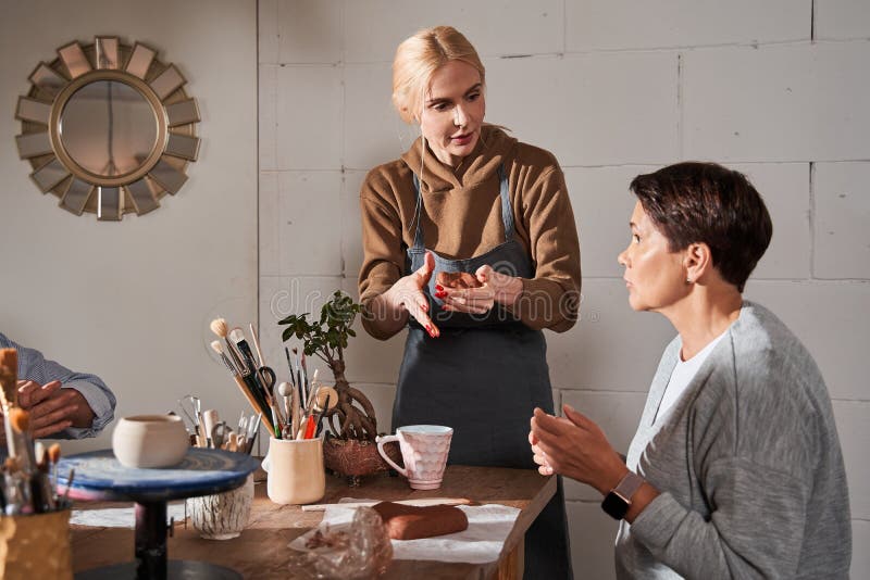 Female Teacher Gesturing while Explaining Something To Her Senior ...