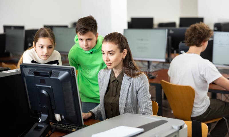 Female Teacher Helping Schoolboy and Schoo Lgirl in Computer Class ... Female Teacher Helping Schoolboy and Schoo Lgirl in Computer Class ...