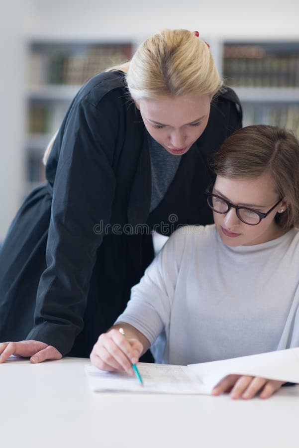 Female Teacher Helping Students on Class Stock Photo - Image of teacher ...