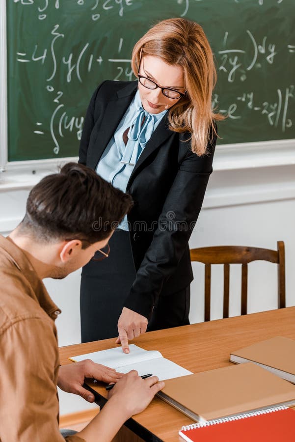 Teacher Pointing at Equations in Classroom Stock Image - Image of ...