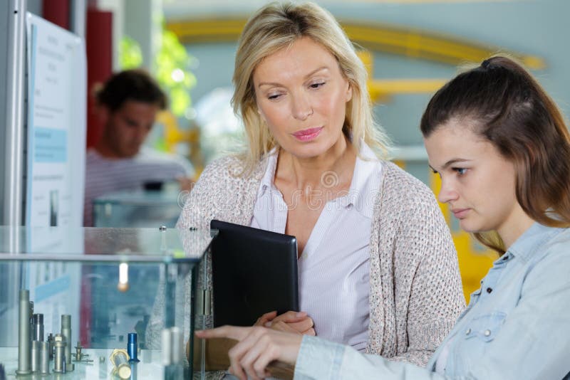 Female Teacher Working with Female Student in Library Stock Photo ...