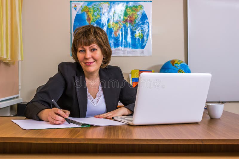 A Female Teacher Works at a Computer in the Classroom Stock Image ...