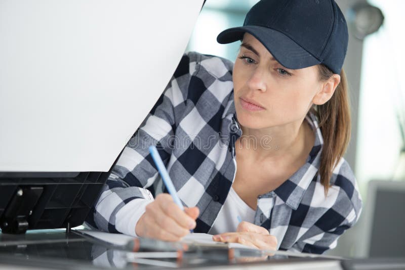 Female Technician Assessing Photocopier and Making Notes Stock Photo ...