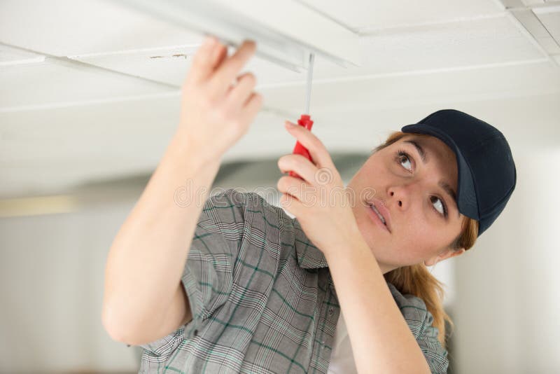 Installing a light fixture stock image. Image of labor - 127171471