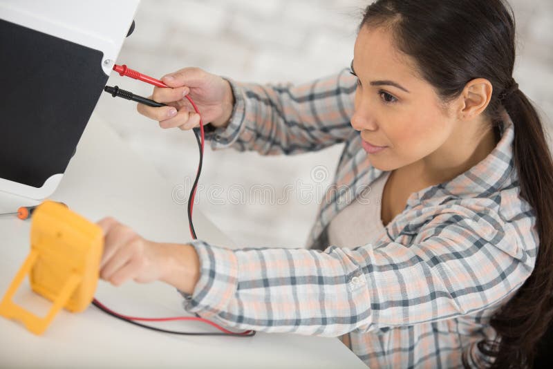 Female Technician Testing Appliance with Multimeter Stock Image - Image ...