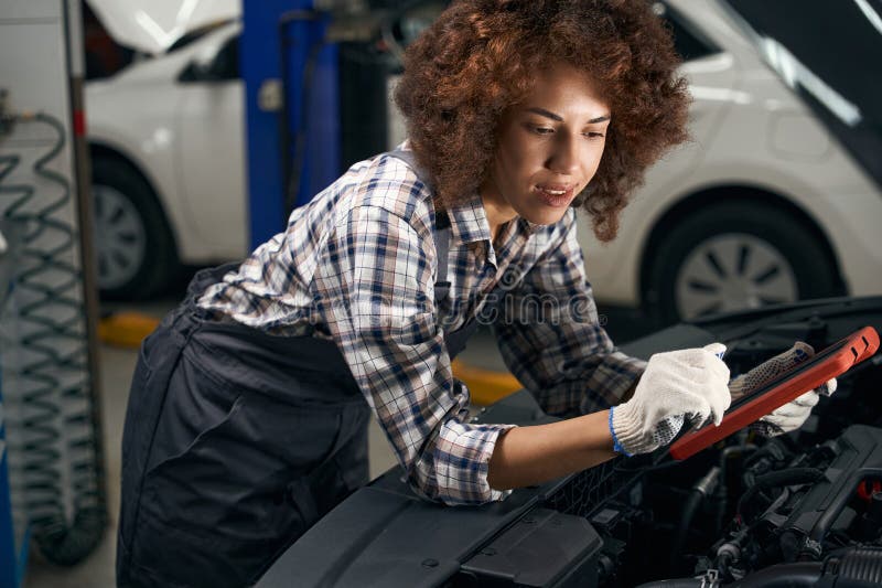 Female Technician in Work Clothes Conducts Computer Diagnostics of Car ...