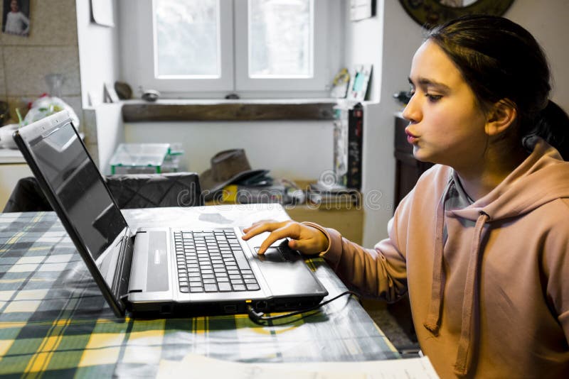 Female Teenager Uses the Computer at Home in the Kitchen on the Stock ...