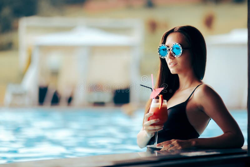 Woman Drinking A Cocktail In The Pool During Summer Vacation Stock
