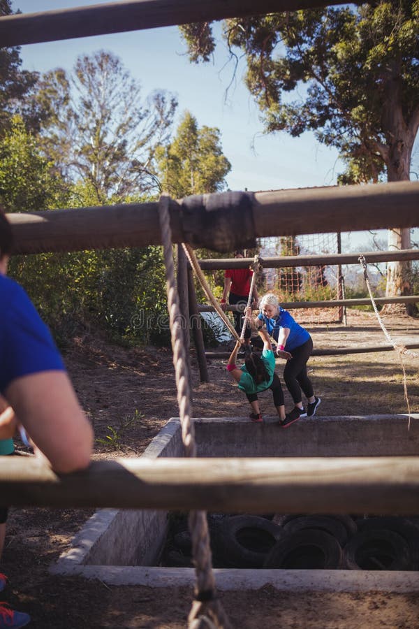 Female Trainer Assisting Women in the Obstacle Course Training Stock ...