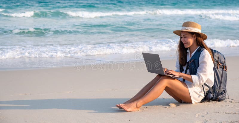 A Female Traveler Using and Working on Laptop Computer on the Beach ...