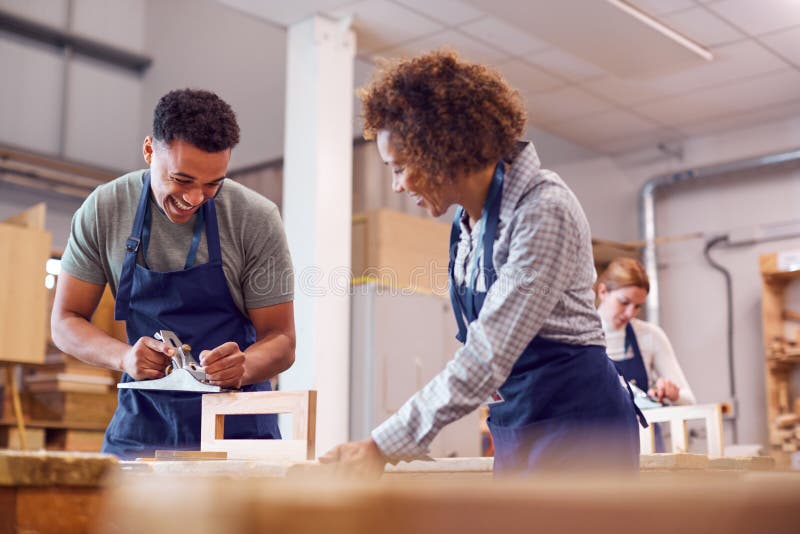 Female Tutor with Carpentry Student in Workshop Studying for ...