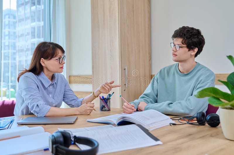 Female Tutor Teaching College Student Guy, in Classroom at Desk Stock ...