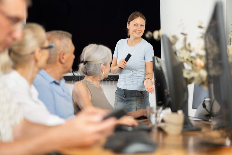 Female Tutor Teaching Group Of Seniors In Computer Workshop Stock Image