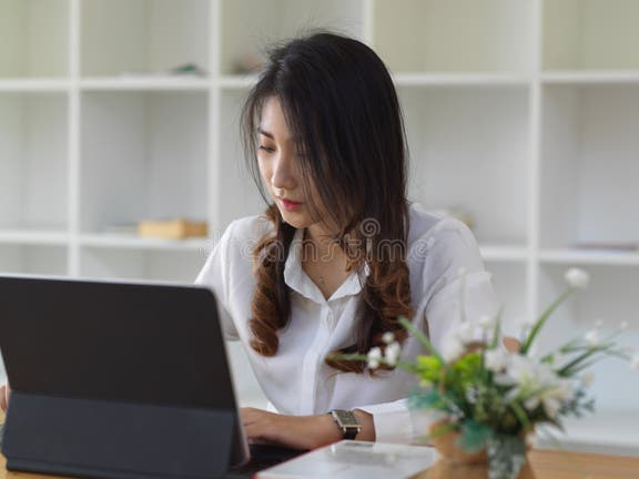 Female University Student Doing Assignment with Tablet in Library Stock ...