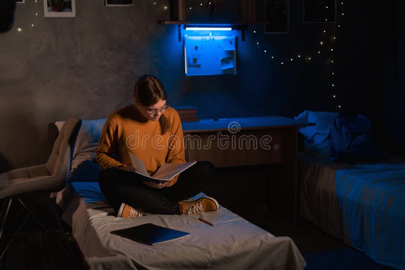 Female University Student with Long Hair Sitting on Bed Doing Homework ...