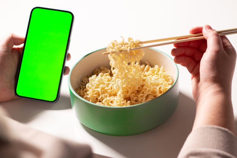 Female Using Smartphone while Eating Pasta at Home. Smartphone with ...