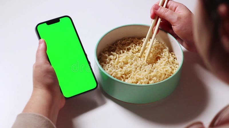 Female Using Smartphone while Eating Pasta at Home. Smartphone with ...