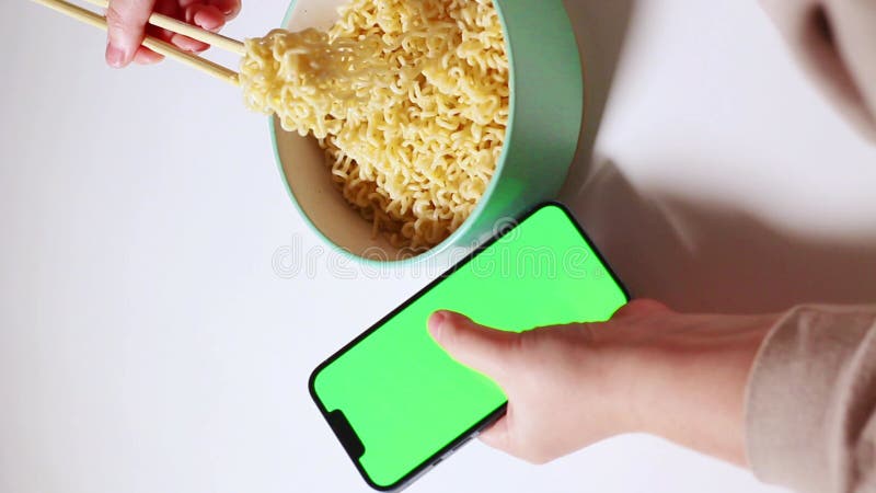 Female Using Smartphone while Eating Pasta at Home. Smartphone with ...