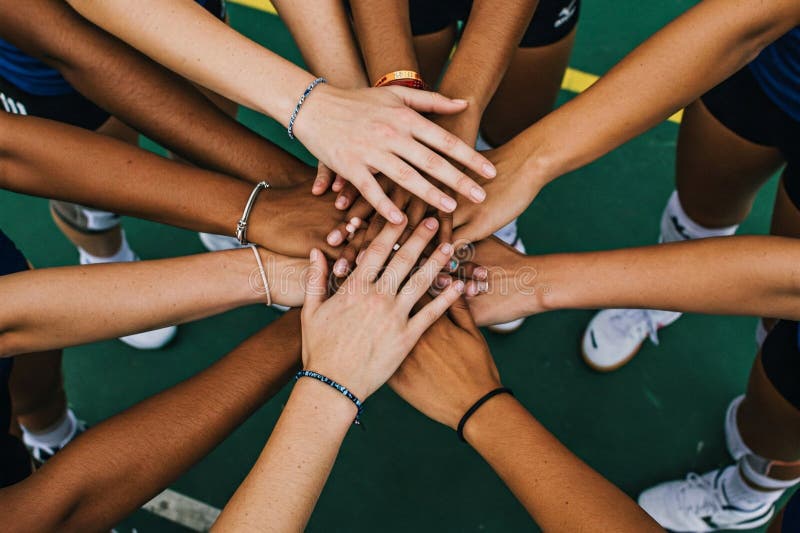 Female Volleyball Players Stack Hands Together in a Circle on the Field ...