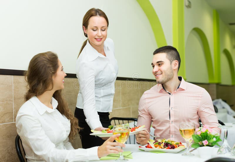 Female Waiter Serving Guests Table Stock Photo - Image of culinary ...