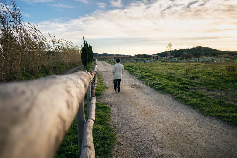Female Walking through the Path in a Rural Area Under the Cloudy Sky ...