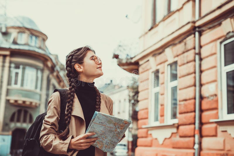 Female Wanderer is Sightseeing, Holding Map in Hands in a Foreign City ...