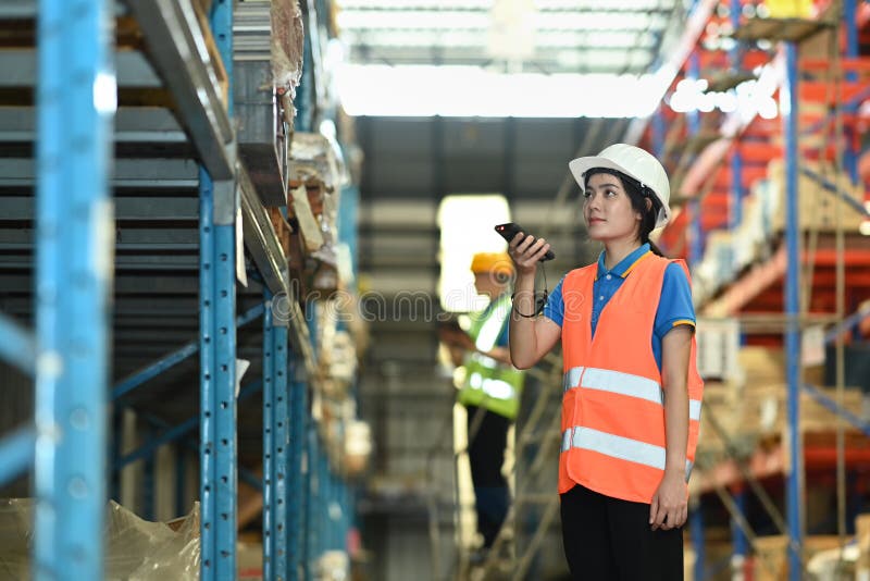Female Warehouse Worker Checking Inventory Boxes with Barcode Scanner on Shelf in a Large ...
