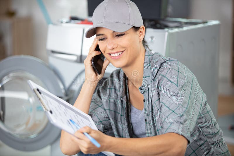 Female Washing Machine Engineer Holds Clipboard and Makes Phonecall ...