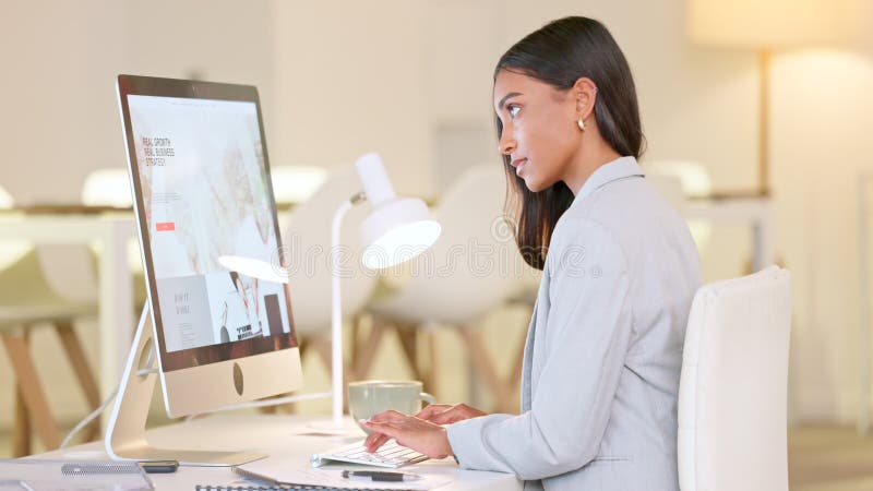 Female Web Designer Typing on a Computer and Comparing Graphic Notes To ...