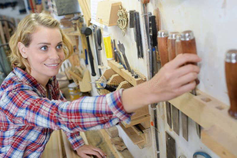 Female Woodworking Artisan Reaching for Chisel in Workshop Stock Image ...