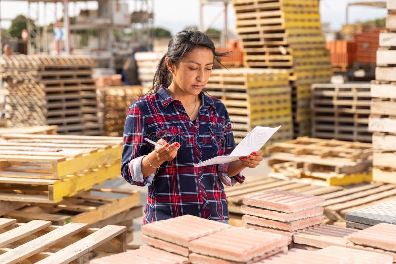 Female Worker Checking Quantity of Paving Slabs in Warehouse Stock ...