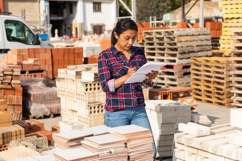 Female Worker Checking Quantity of Paving Slabs in Warehouse Stock ...
