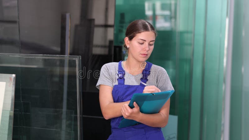 Female Worker Checks the Quality of Made Window Glass in an Industrial ...