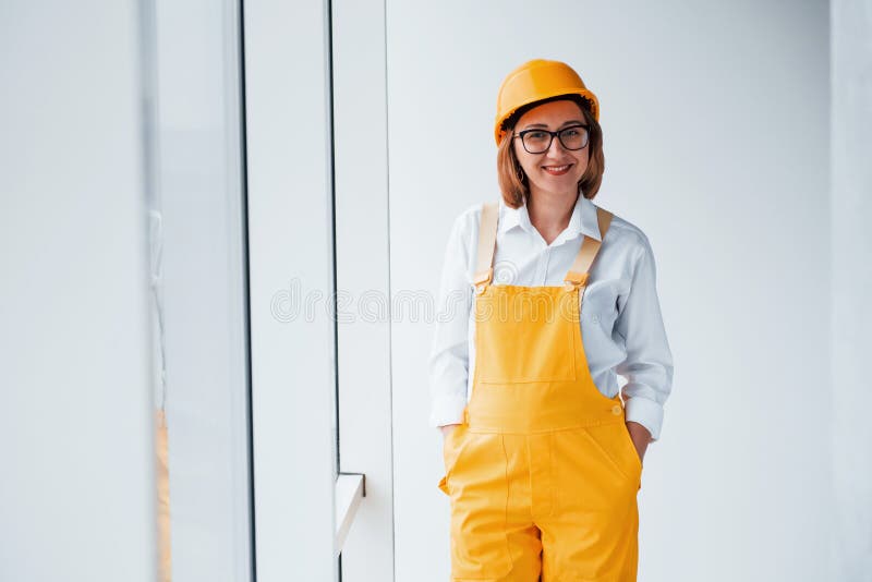 Female Worker or Engineer in Yellow Uniform and Hard Hat Standing ...