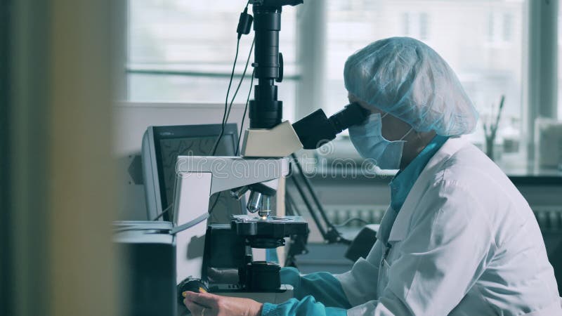Female Worker is Exploring a Capsule Pill Under a Microscope Stock ...